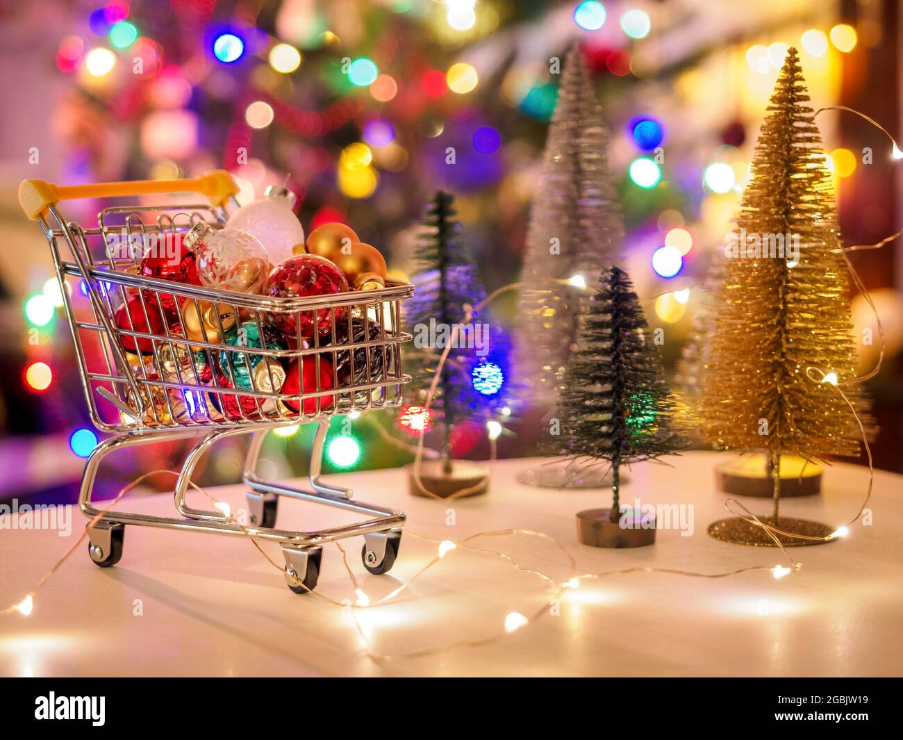 small shopping cart full of christmas decorations and with lights on a ...