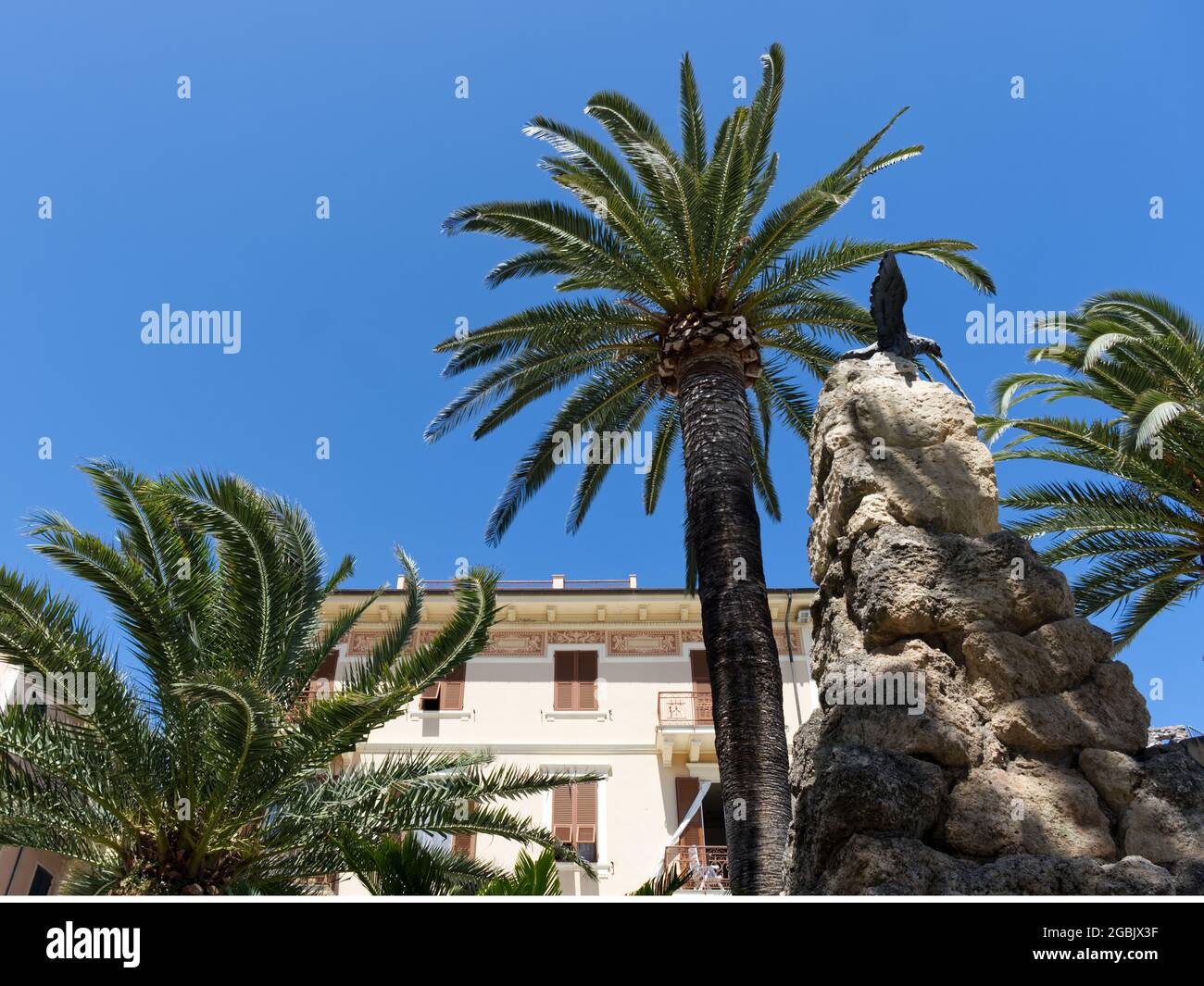 palm tree in the square of a typical ligurian city, an Italian holiday ...