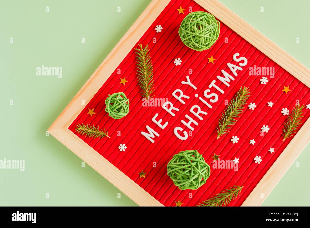 merry christmas text wit green fir tree branches and ratang balls on ...
