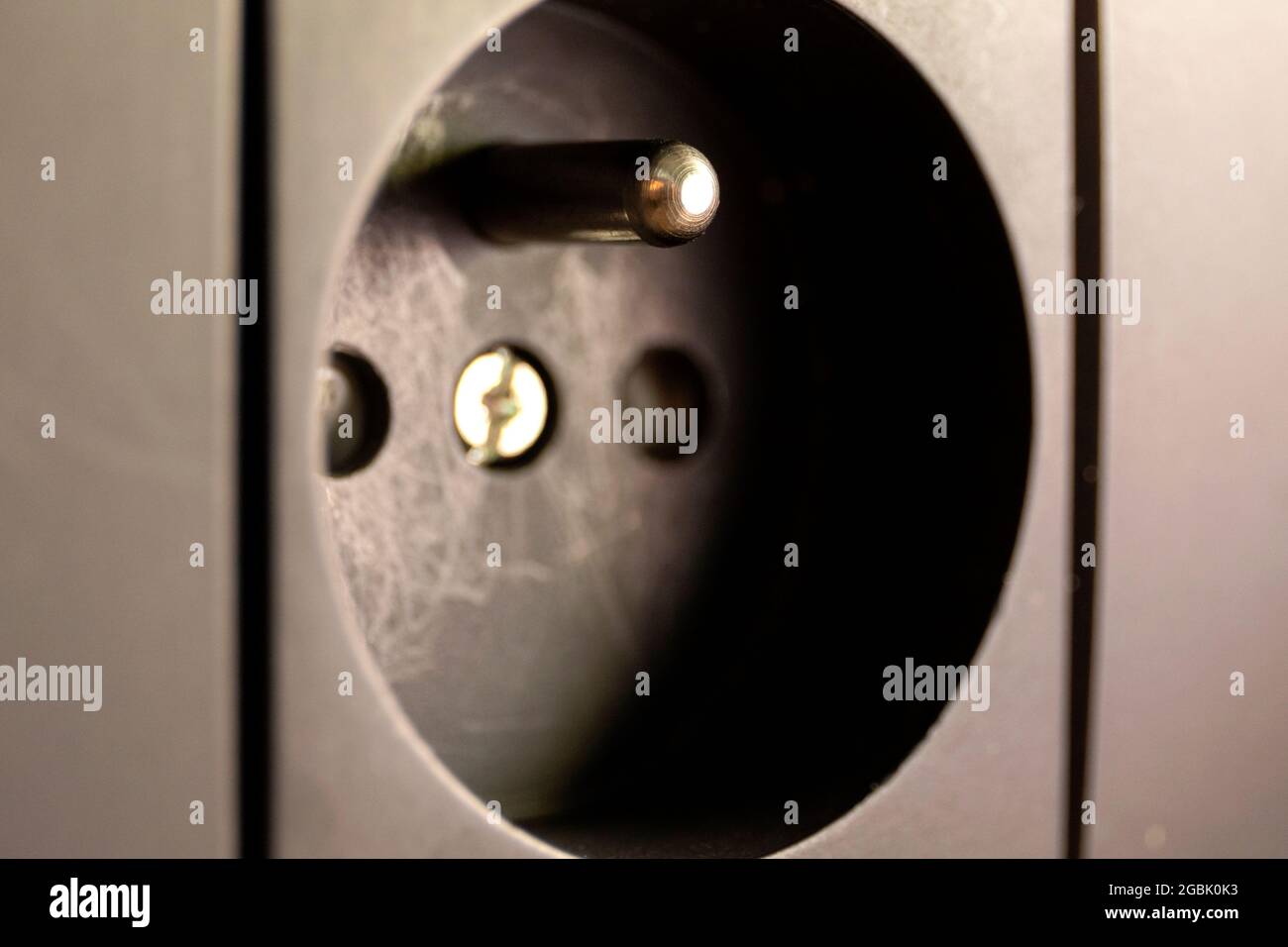 A close up portrait of a type E wall socket used to supply electric or ...