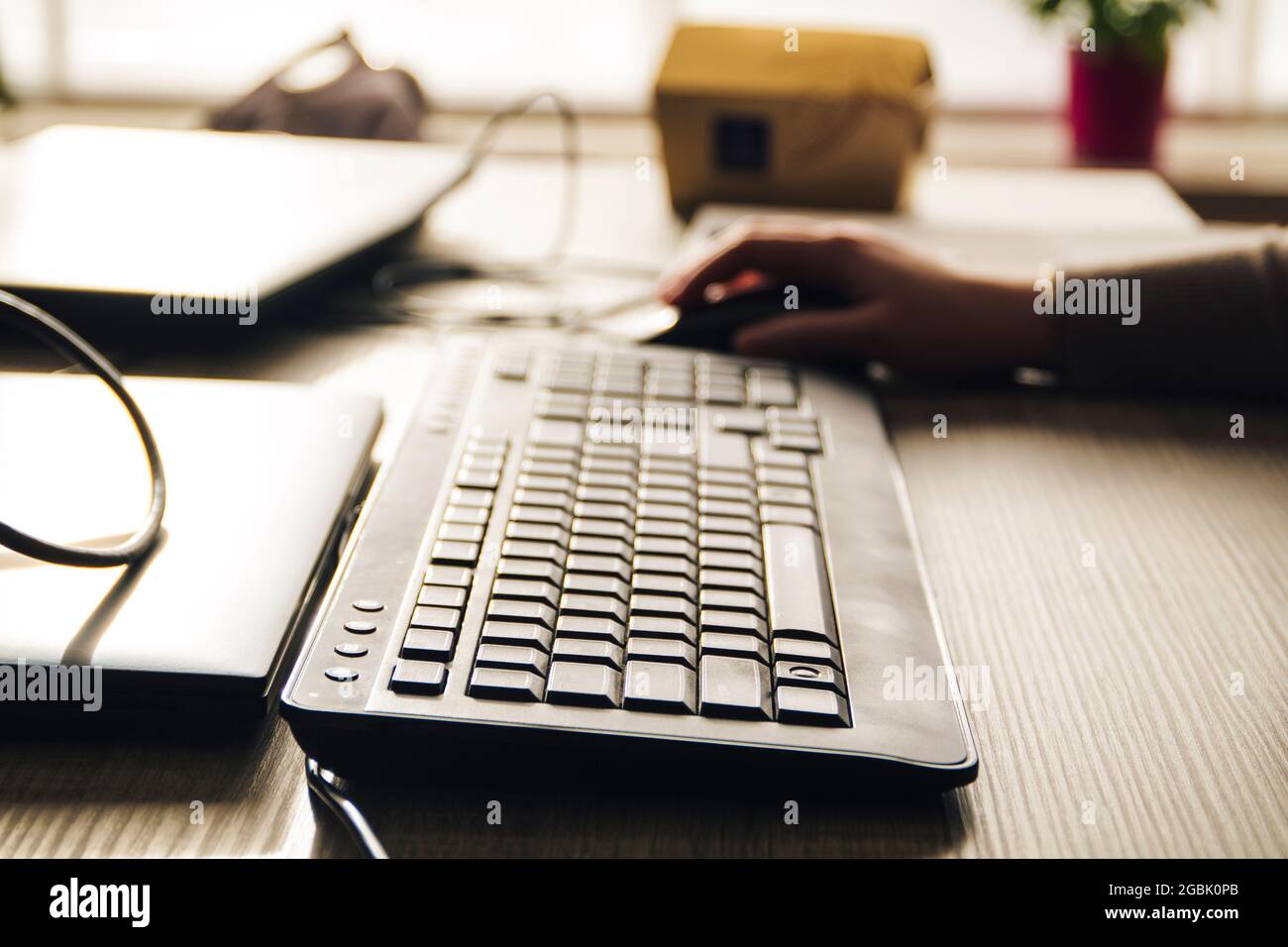 A portrait of a computer keyboard lying on a wooden table with someone ...
