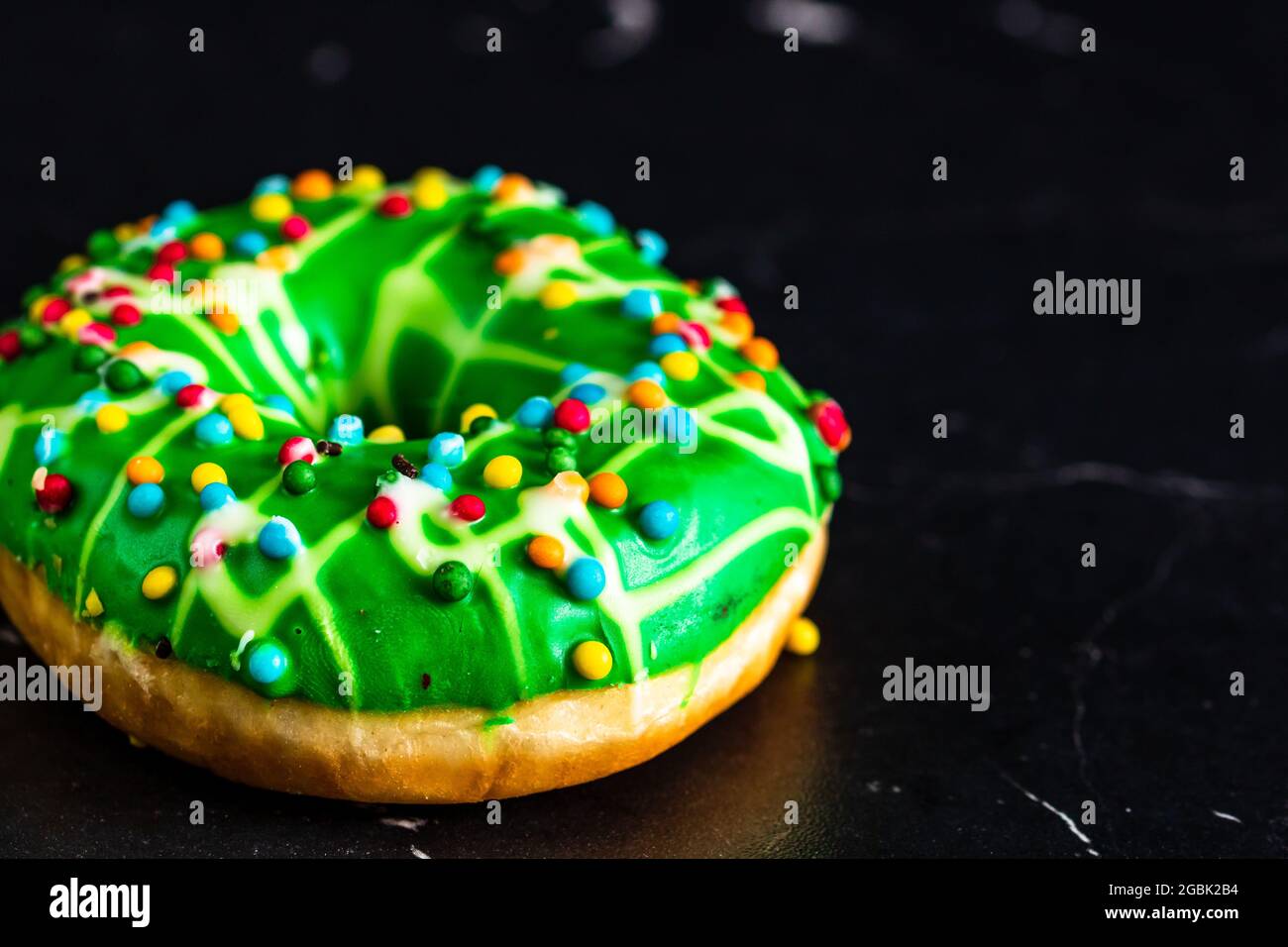 Green glazed donut with sprinkles isolated. Close up of colorful donuts ...