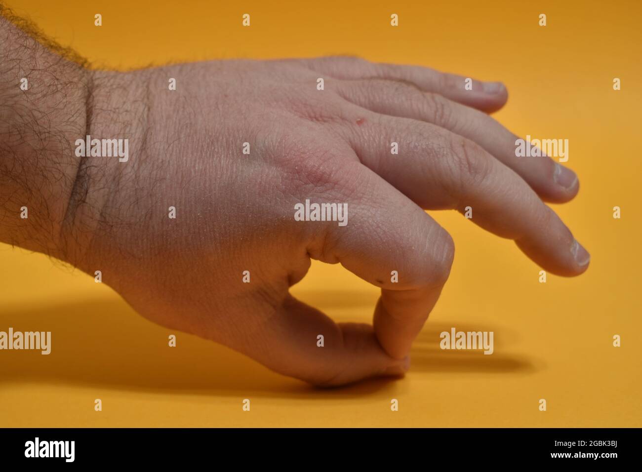 Male's hand showing "OK" sign on a yellow background Stock Photo - Alamy
