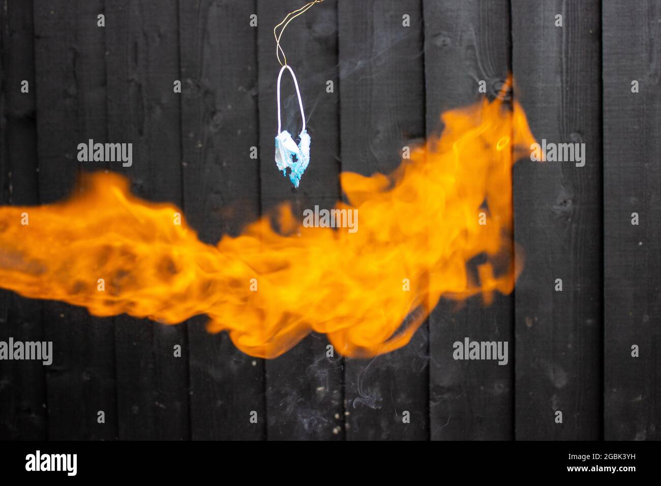 Burning single-use mask on a wooden wall background - lockdown lifted ...