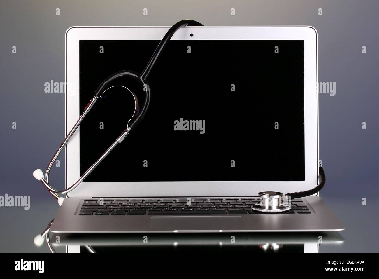 Silver notebook with a stethoscope on grey background with reflection ...