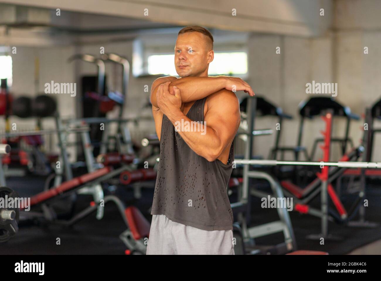 Fitness man warming up in gym. Male doing warm up stretching workout on ...