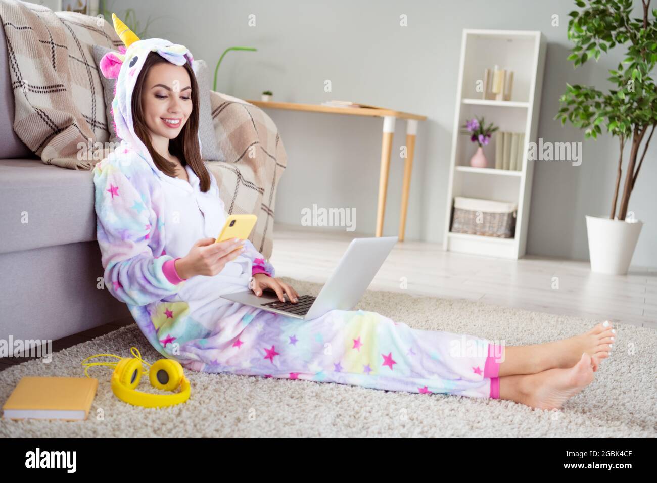 Photo of charming positive adorable blogger lady sit floor hold laptop ...