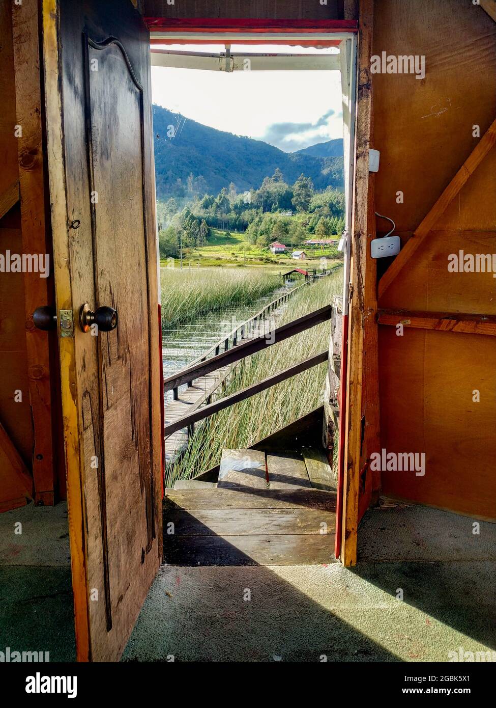 Open door showing a view of a canal and a forest in the background ...