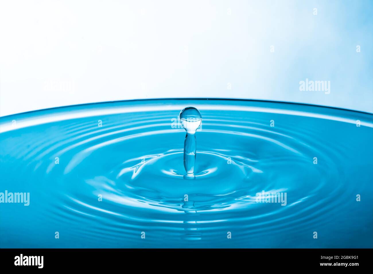 Water drop on blue background. Blue water surface with splash. Clear ...
