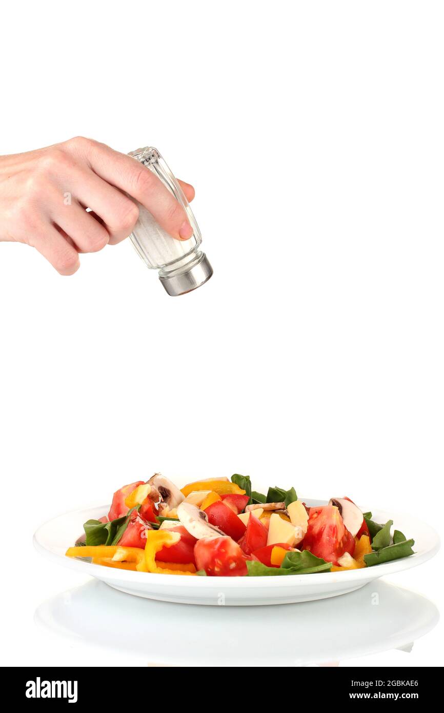 Hand adding salt using salt shaker isolated on white Stock Photo - Alamy