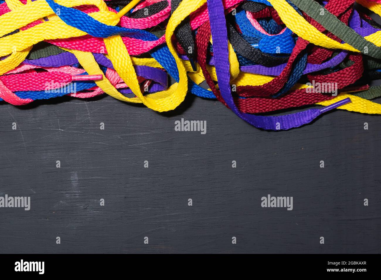 colorful shoelaces background, on black wood, messy, clutter concept ...