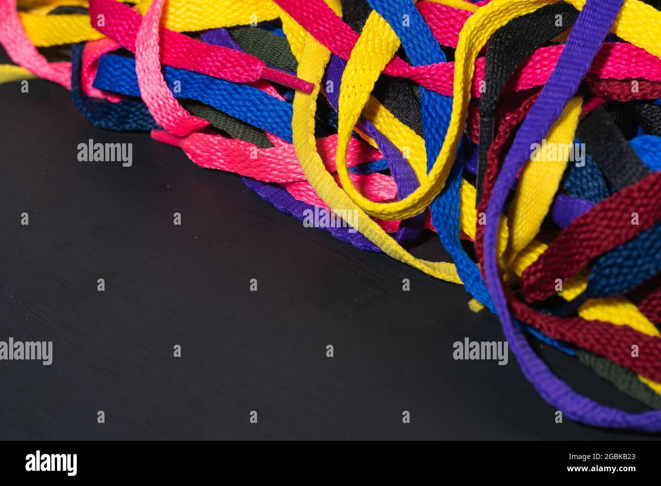 colorful shoelaces background, on black wood, messy, clutter concept ...