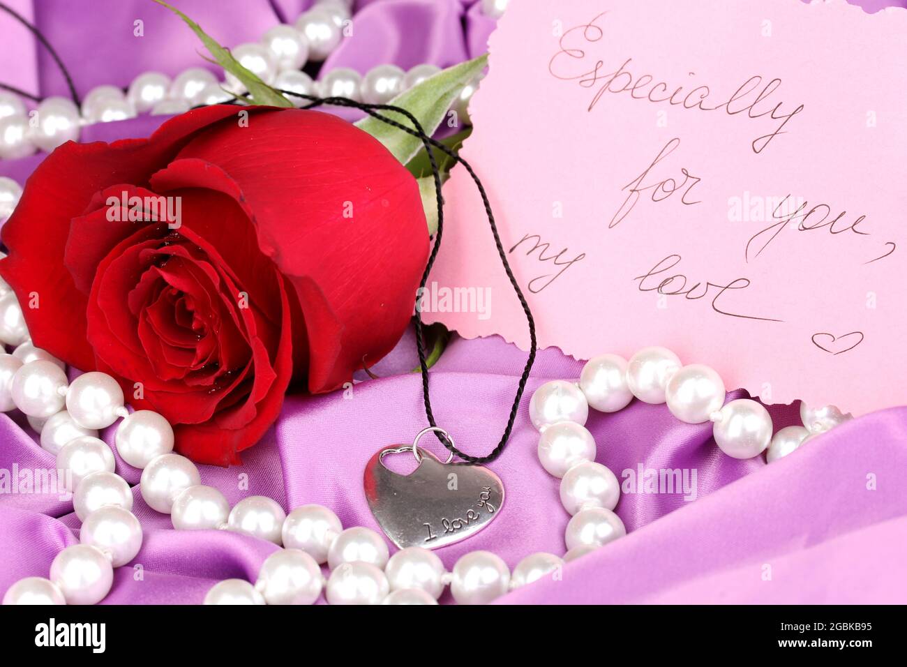 Heart pendant with red rose Stock Photo - Alamy