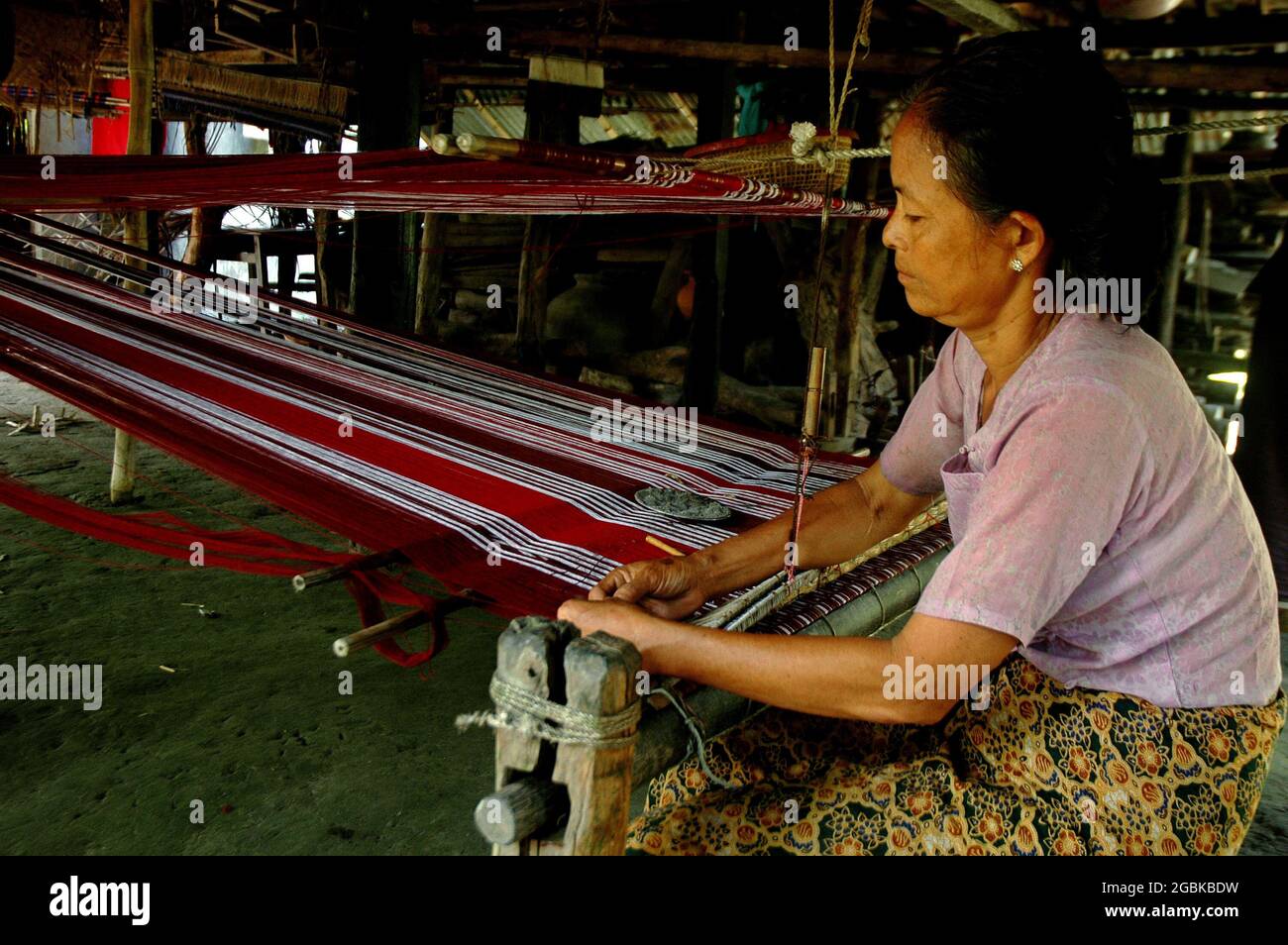 A woman from the ethnic Rakhain community weaving cloth with a ...