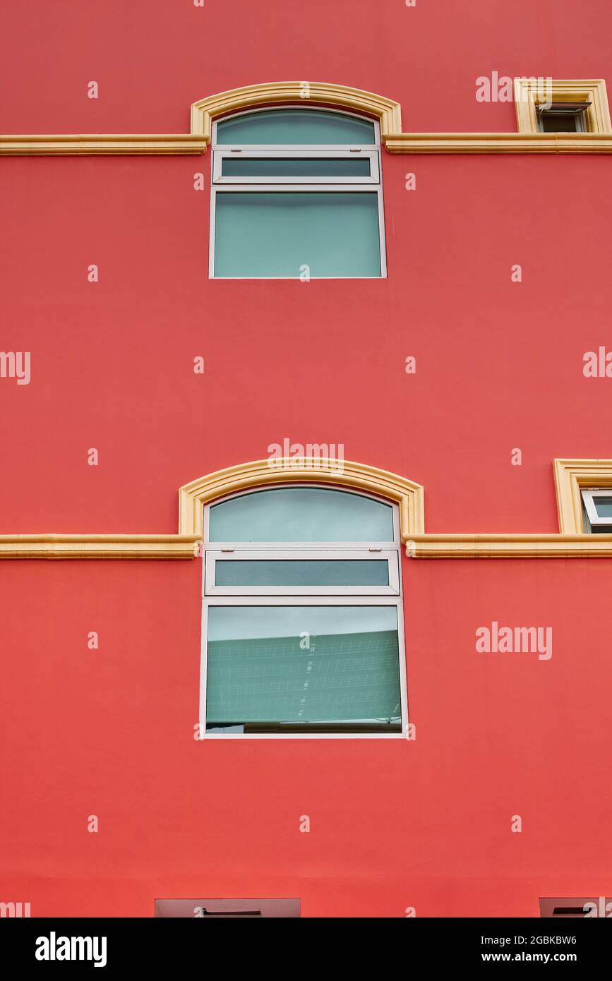 Salmon-colored hotel facade with symmetrical windows Stock Photo - Alamy