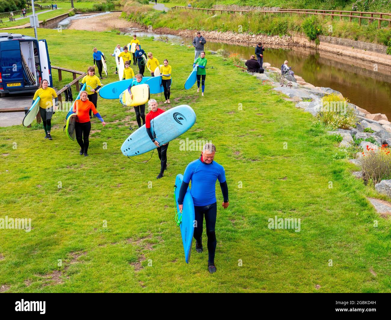 Surf School learners after a briefing on the grass walking down to ...