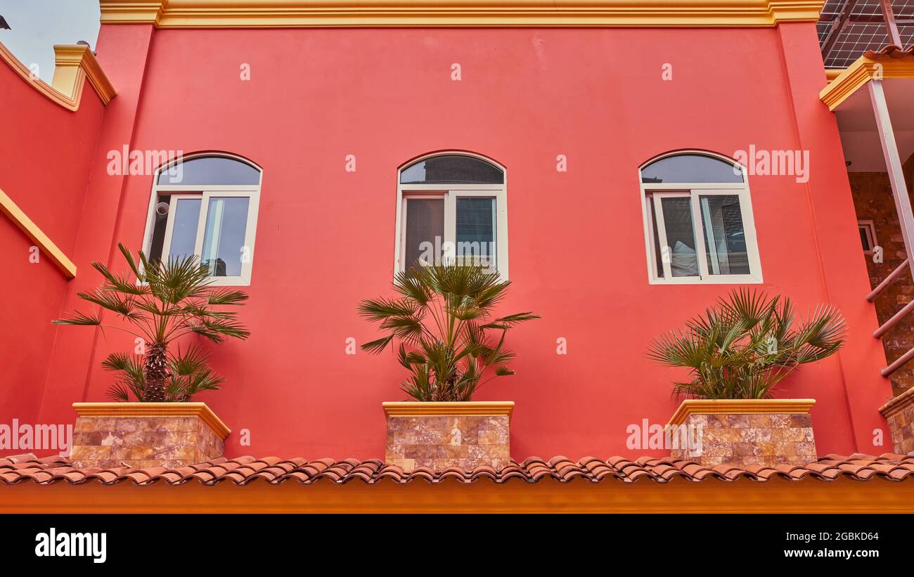 Salmon-colored hotel facade with symmetrical windows Stock Photo - Alamy