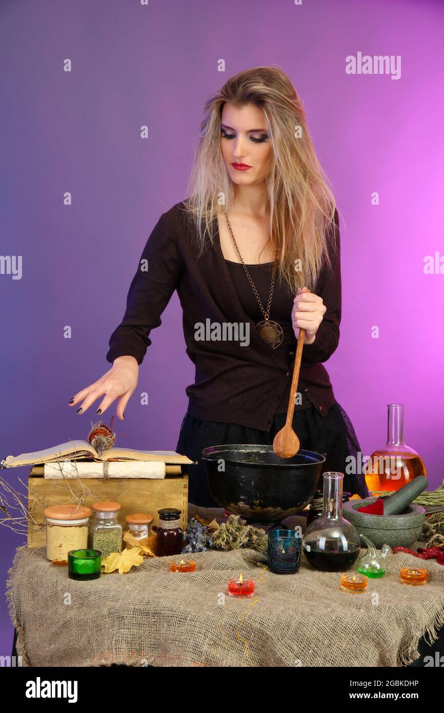 Halloween witch stirring in poison soup in her cauldron on color ...