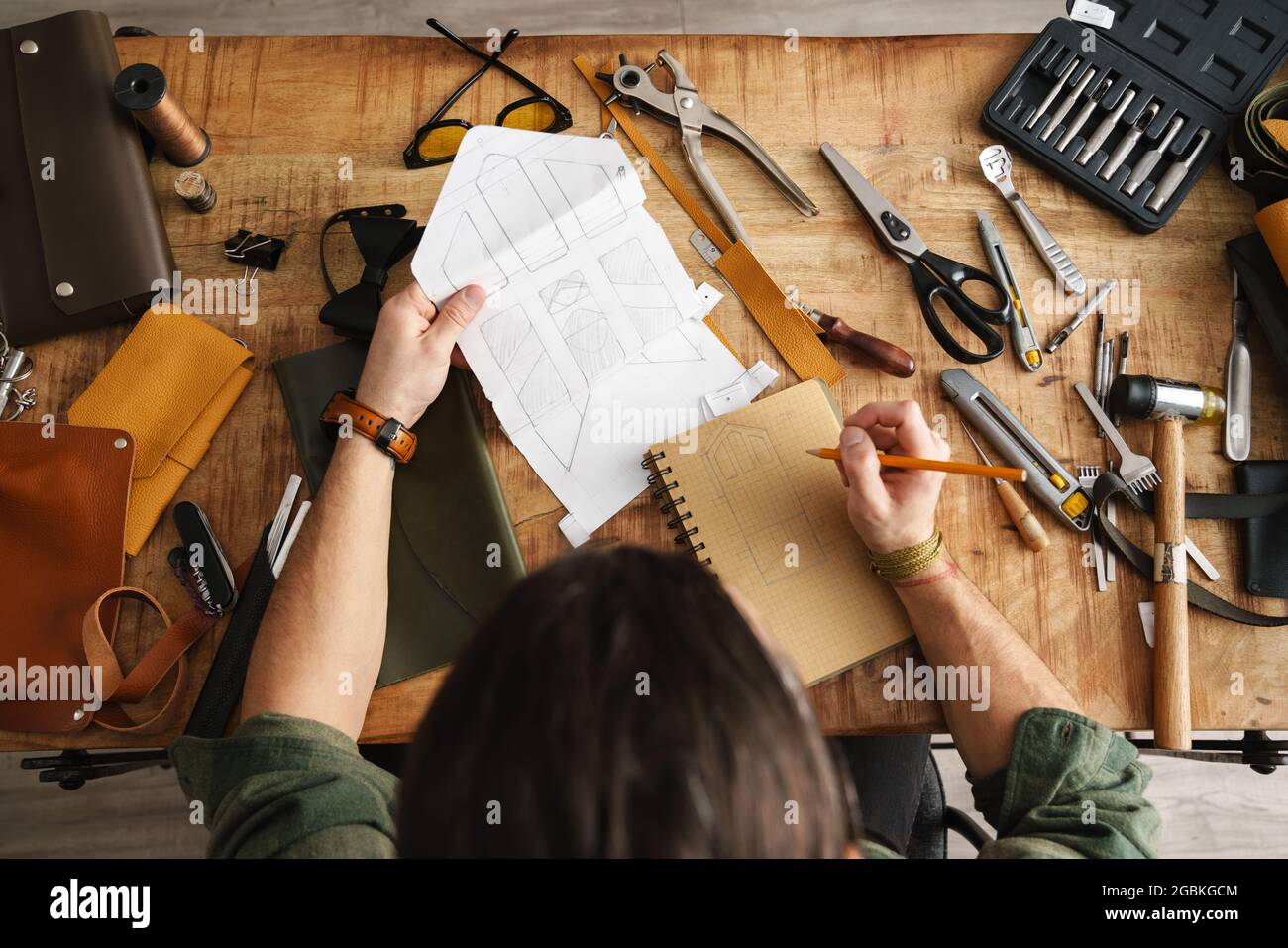 White craftsman drawing while working with leather in workshop Stock ...