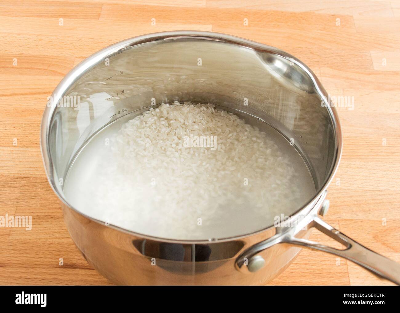 White rice in water in a ladle Stock Photo - Alamy