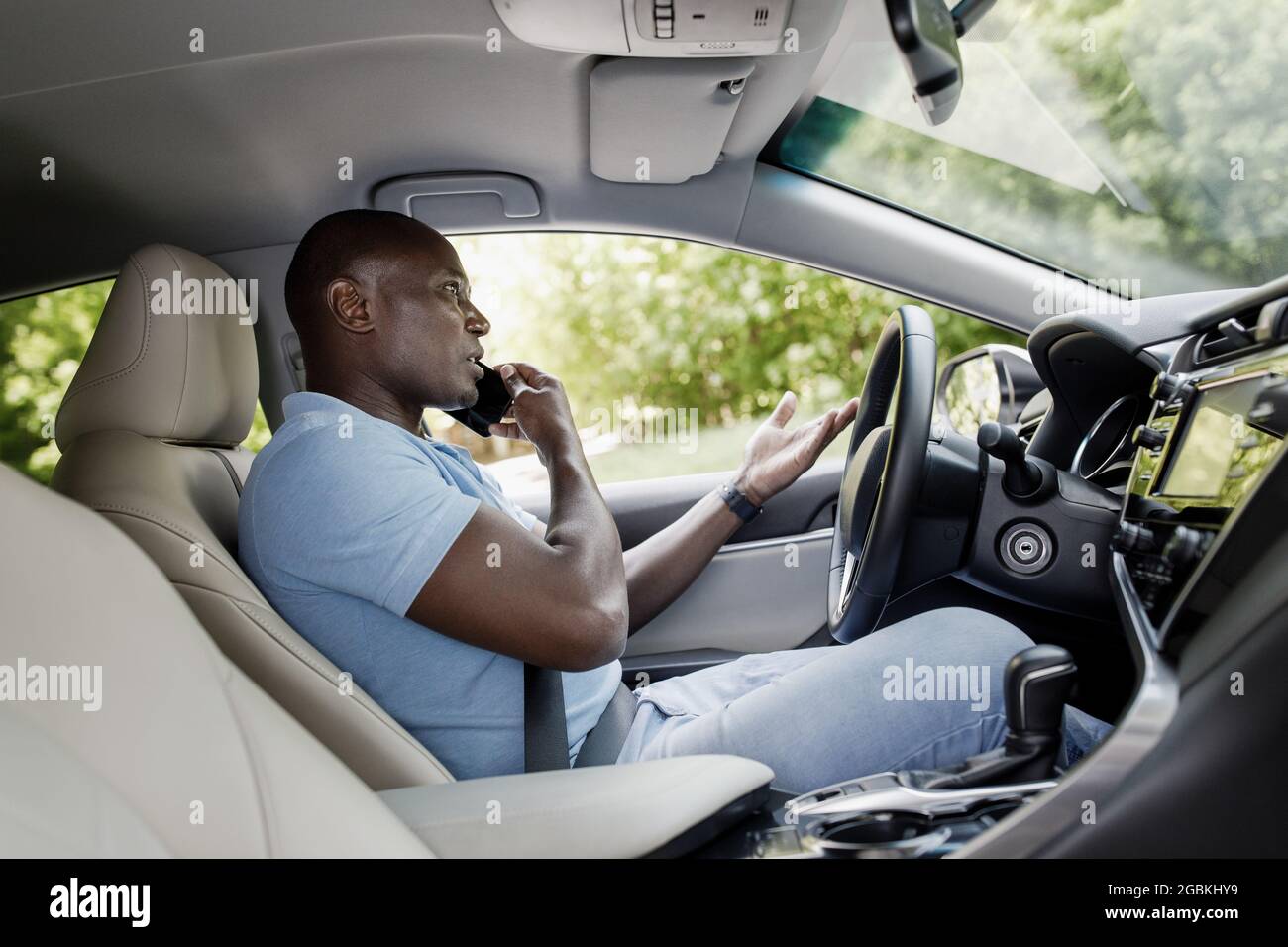 Emotional black man having phone conversation while driving car Stock ...