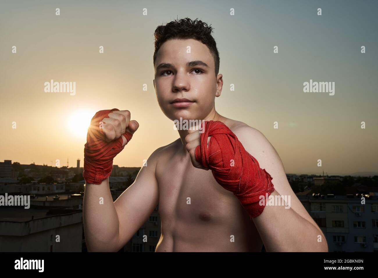 Young teenage kickboxer fighter training on the roof with buildings in ...