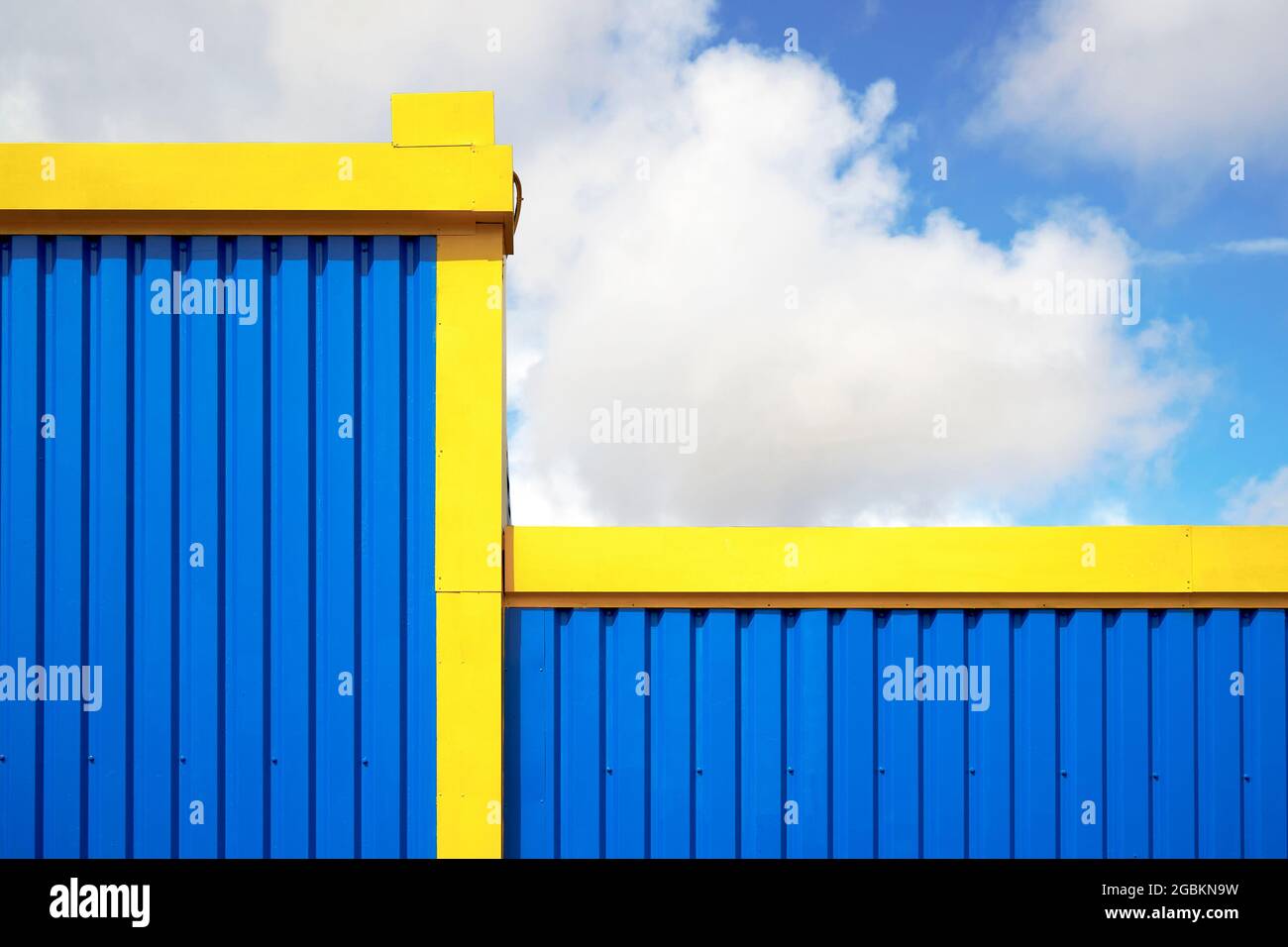 Abstract of brightly coloured blue and yellow building with blue sky ...