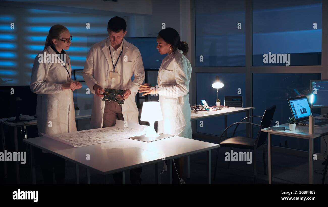 Diverse group of engineers discussing electronics development with ...