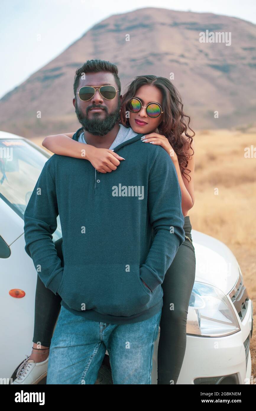 Vertical shot of a happy young Indian couple, girl hugging her boyfriend from behind Stock Photo ...