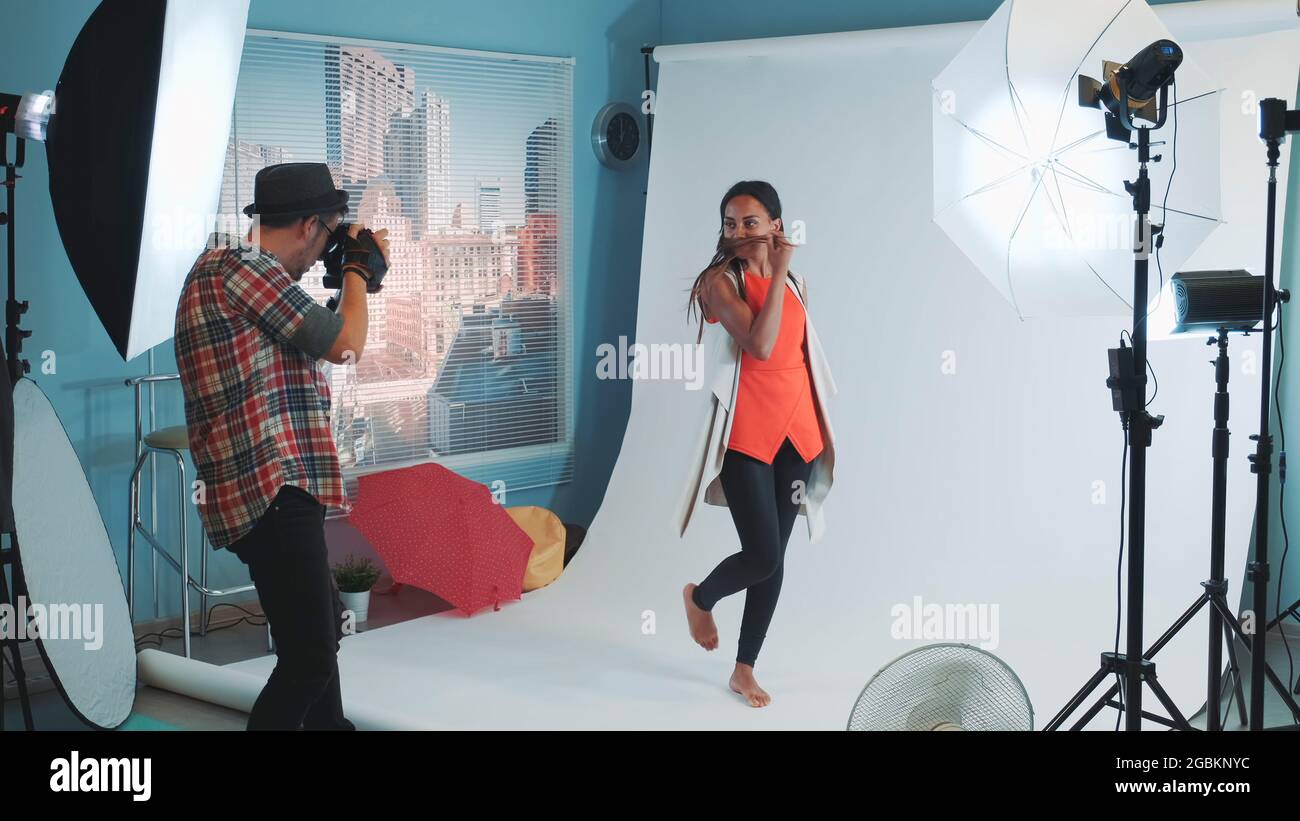 Beautiful smiling model of african ethnicity posing for a photographer ...
