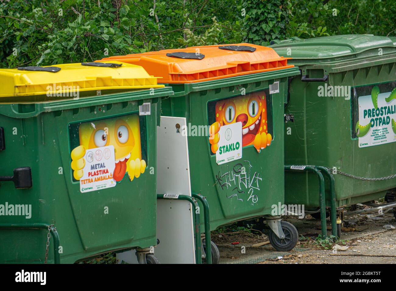 Group of three green trash containers for recycling different materials ...