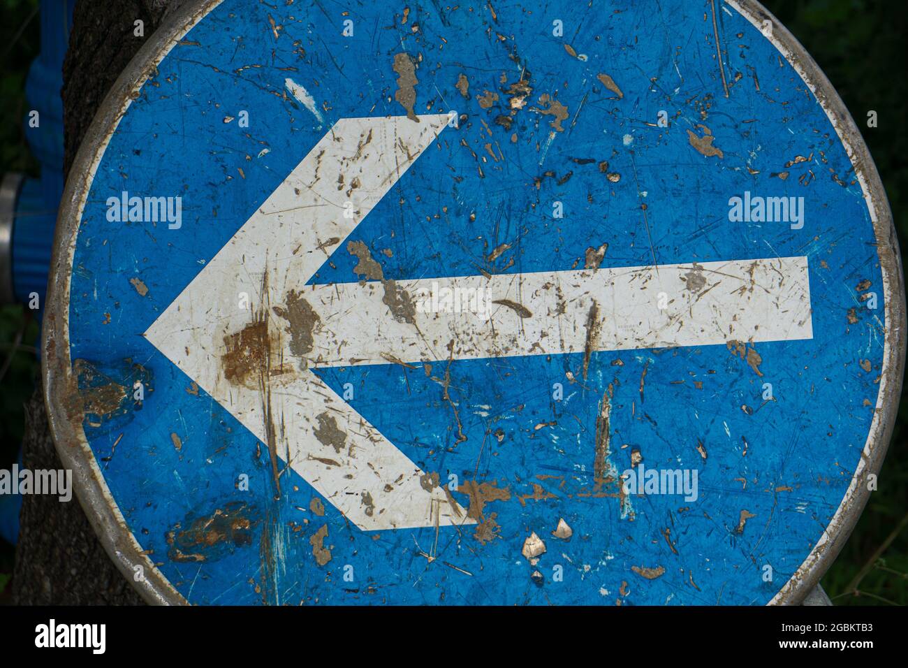 Old scratched blue street sign with an arrow in the middle showing to ...