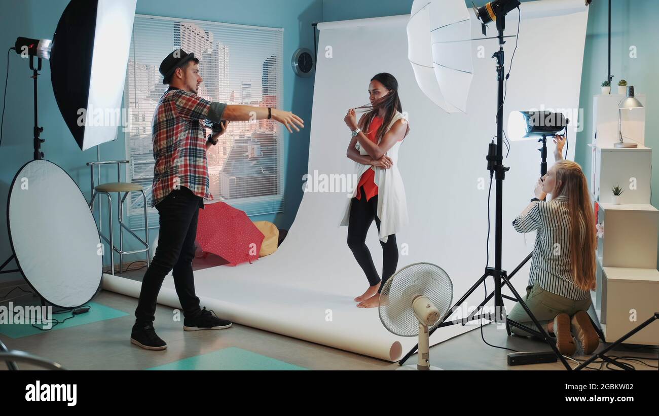 Backstage of the photo shoot: assistant adjusting the spotlight while ...