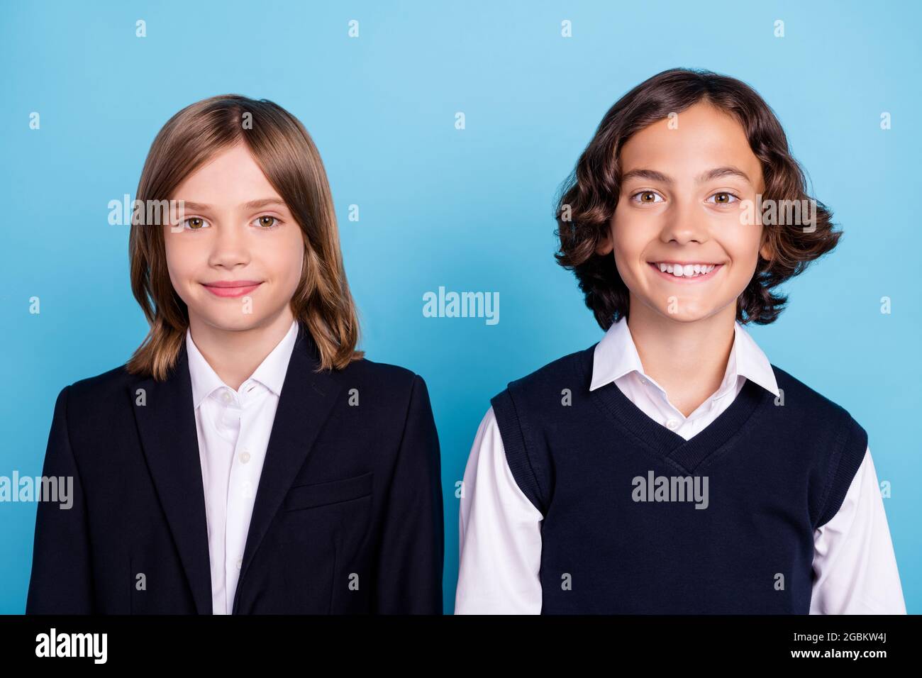 Photo portrait two school mates smiling in uniform sitting on lesson ...