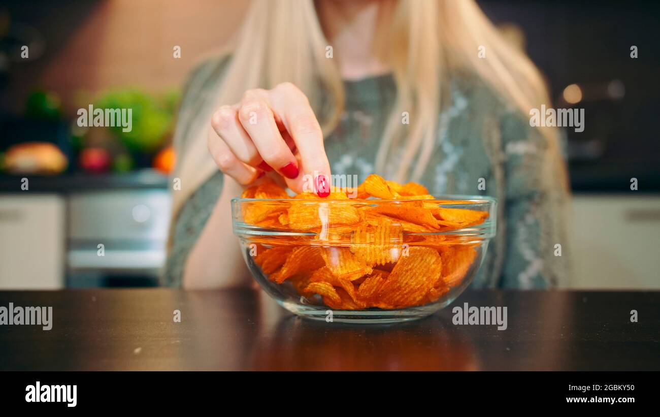 Close-up shot of woman eating potato chips. Beautiful young female ...