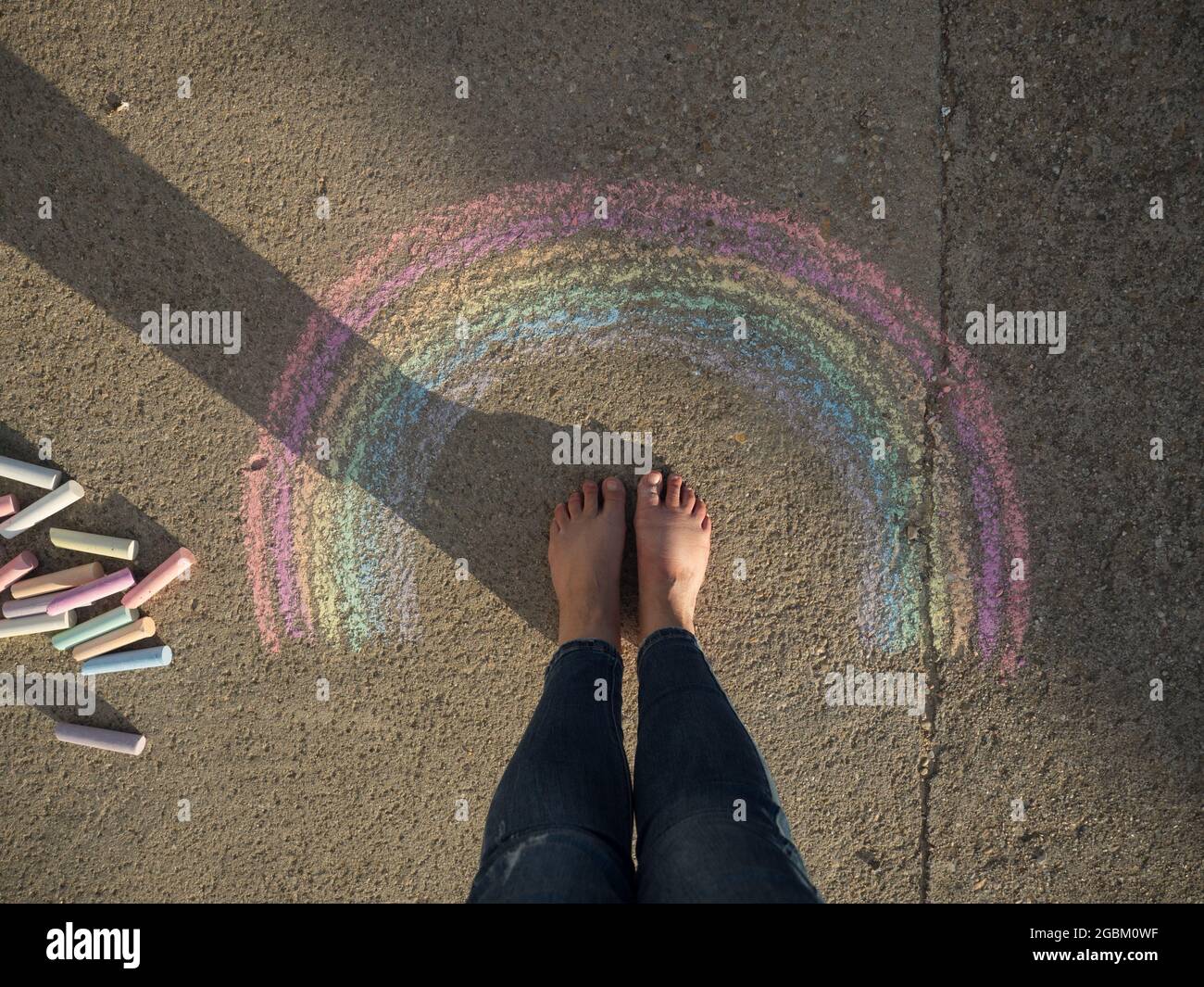 Two feet standing in a drawing of a rainbow Stock Photo - Alamy