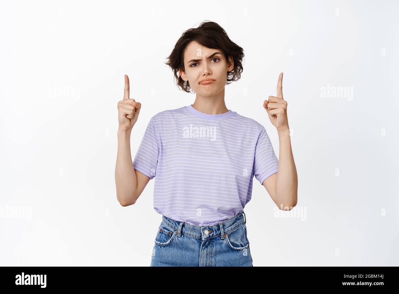 Skeptical frowning woman pointing fingers up, bad idea, complaining ...