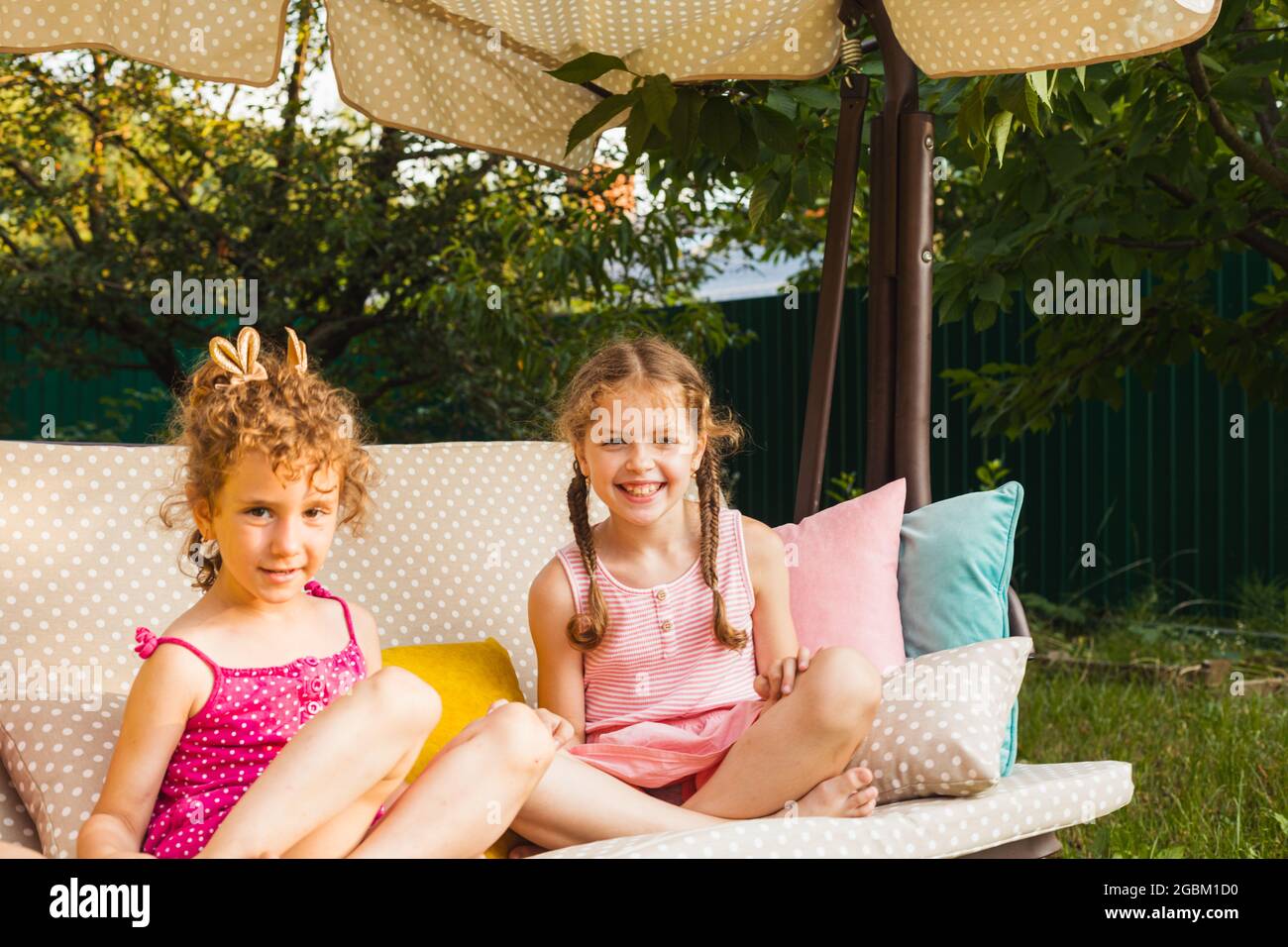 Three lovely sisters on soft garden swing Stock Photo - Alamy