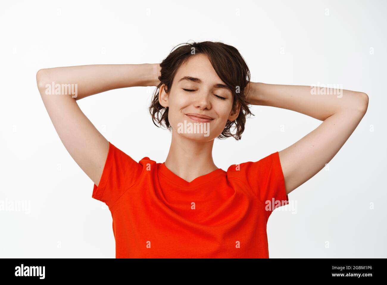 Young woman resting, lay back with hands behind head, close eyes and ...