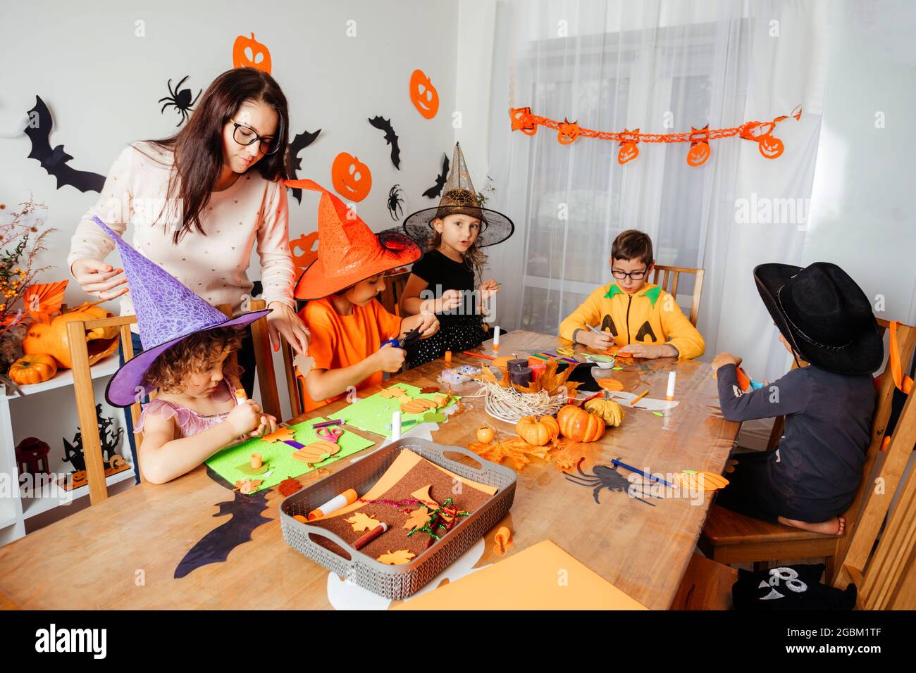 Teacher helping creative children to make paper bookmarks Stock Photo ...
