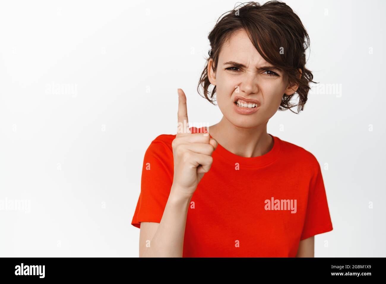 Disappointed and frustrated young woman shaking finger, scolding, angry ...
