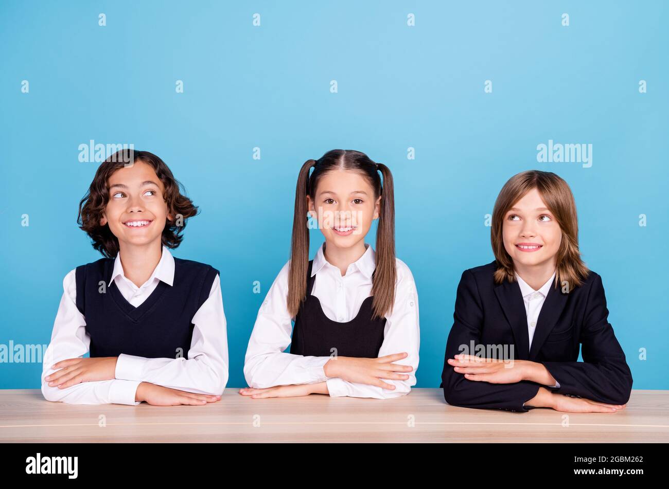 Photo portrait school mates smiling in uniform sitting at desk looking ...
