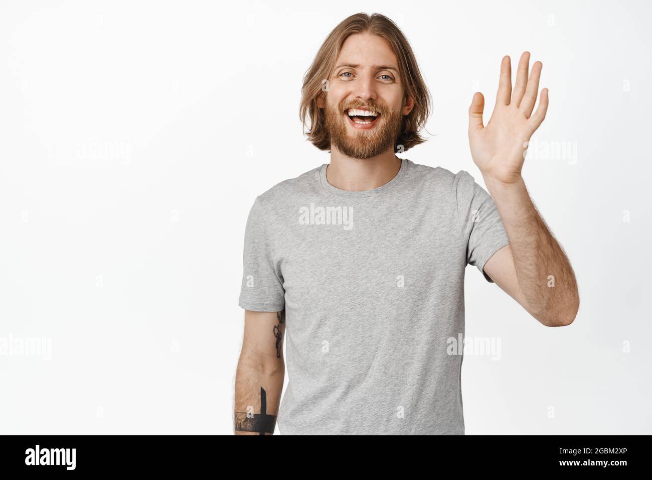 Image of friendly blond guy, greeting you, smiling happy and waving ...