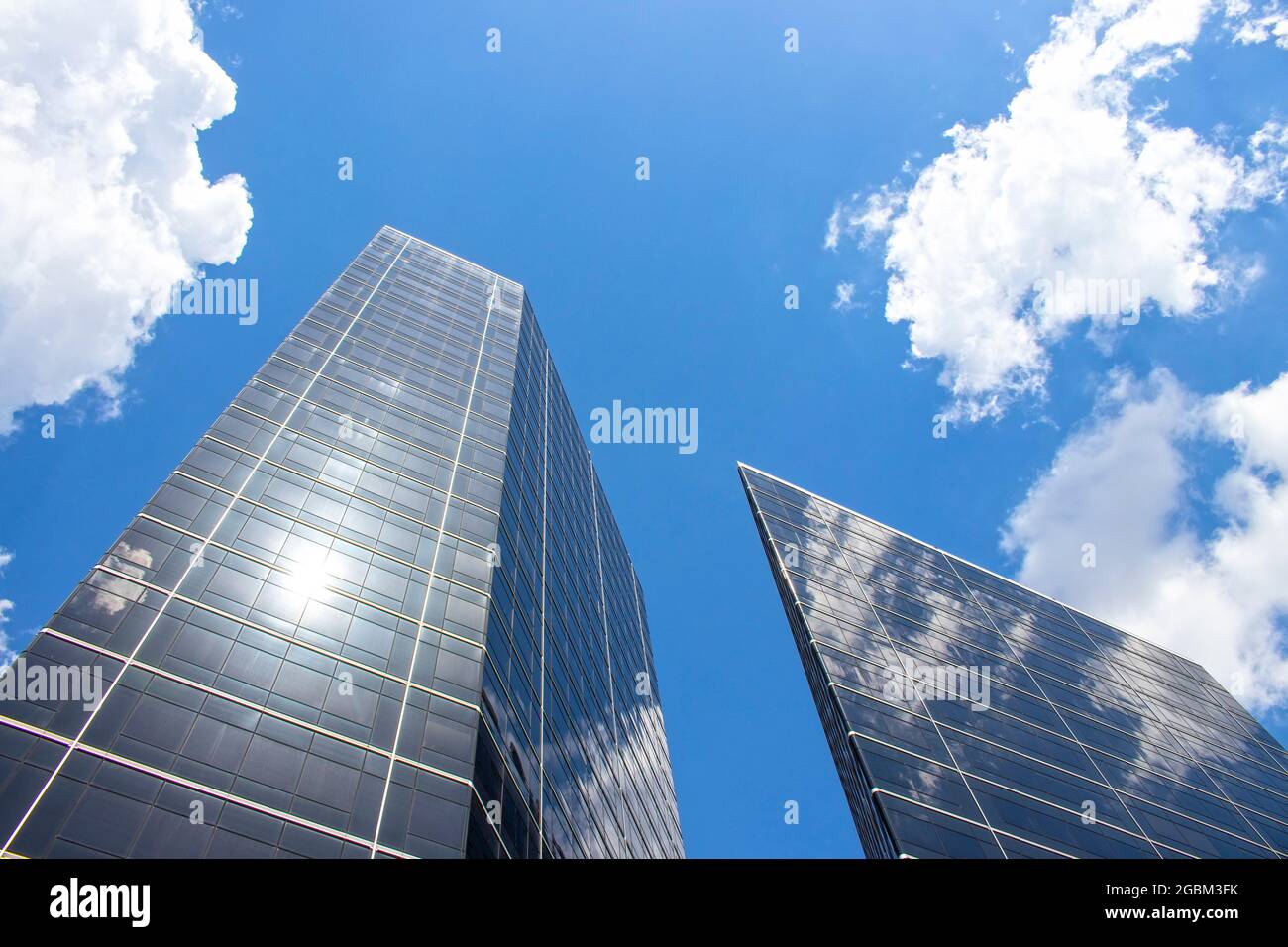 Reflection of sky and clouds on tall modern skyscrapers looking up with ...