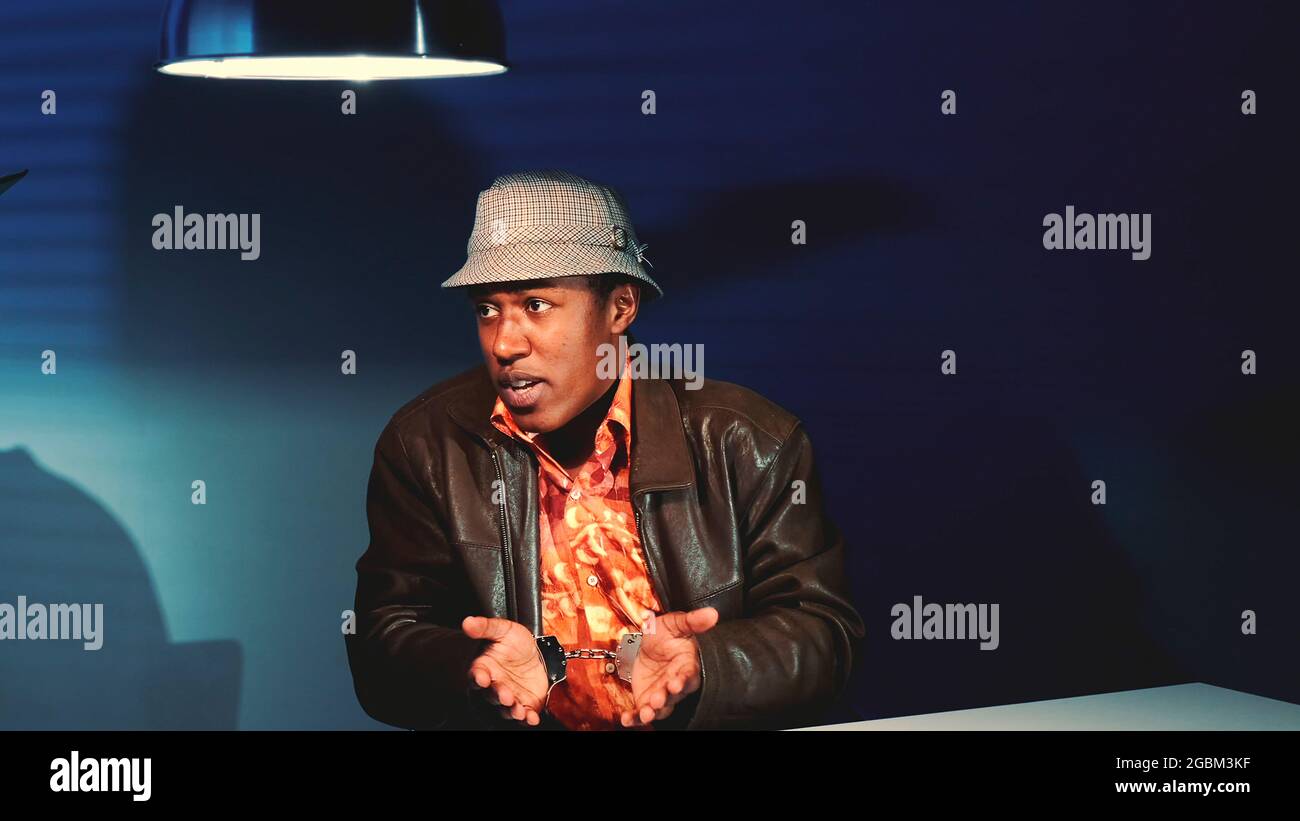 Young black man in handcuffs refusing accusation in his address during ...