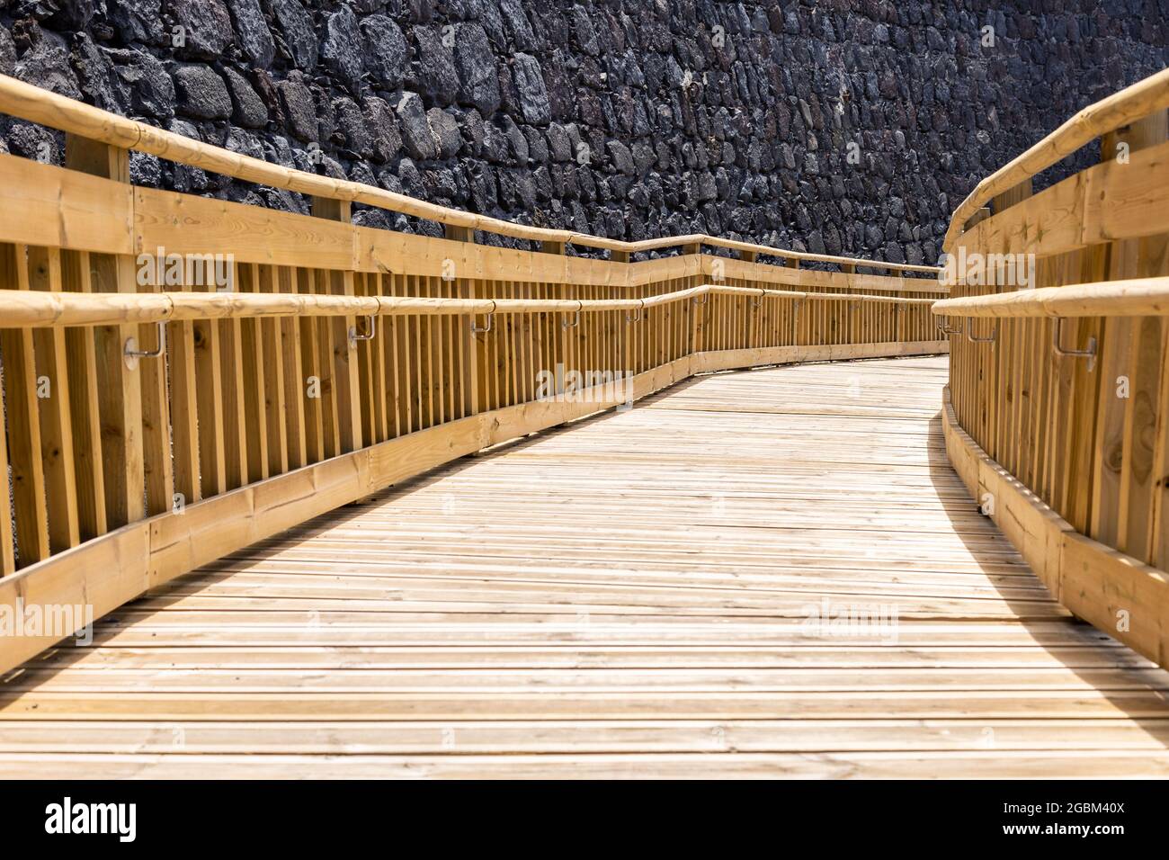 View of a wooden road with railings near the brick wall Stock Photo - Alamy