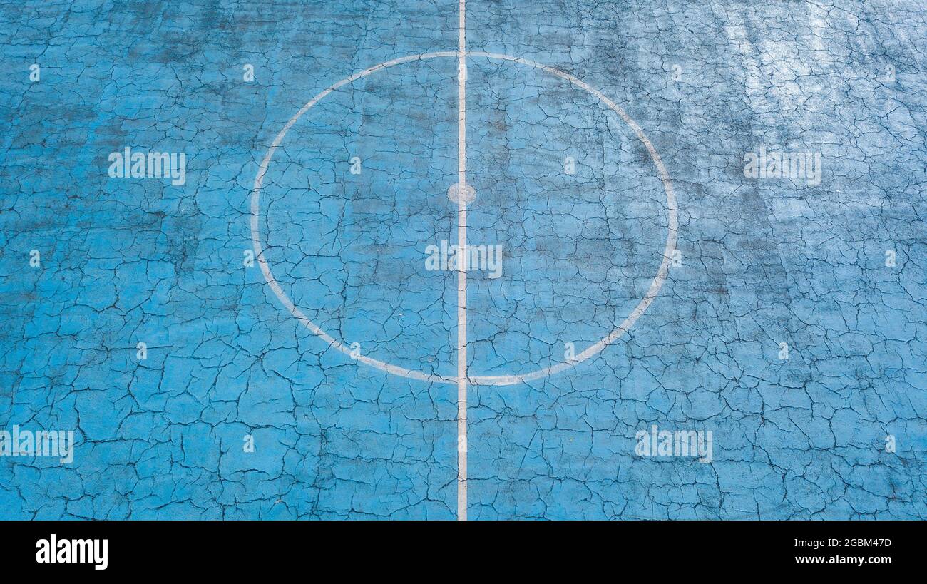 Multi-sport court with a central circle and a floor painted blue and ...