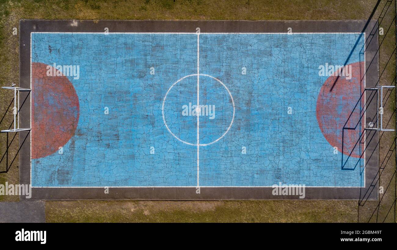 Multi-sport court with a central circle and a floor painted blue and ...