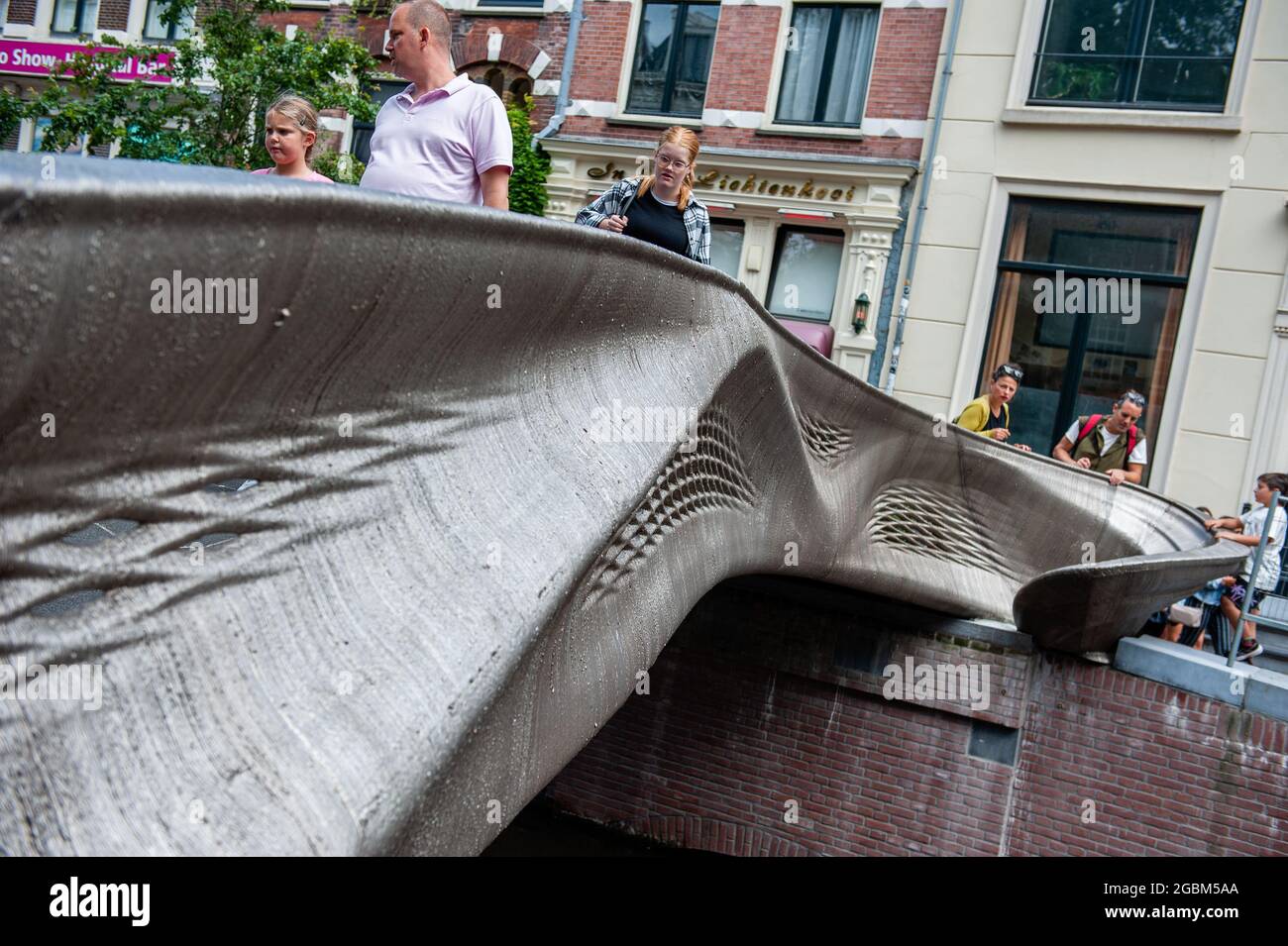 A family is seen crossing the bridge.A 12-meter 3D-printed pedestrian ...