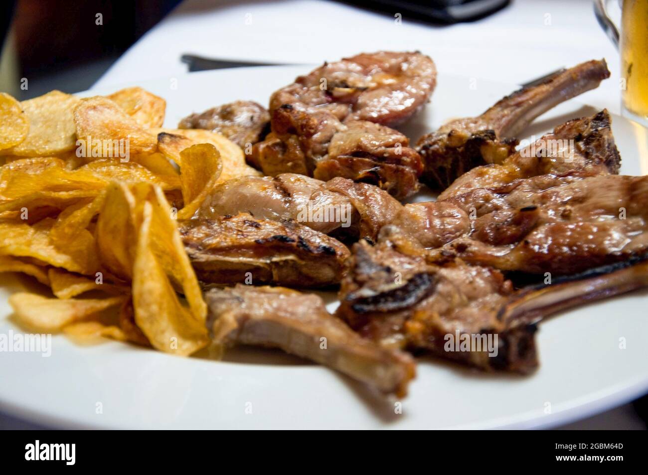 Extremadura suckling lamb chops with potato chips Stock Photo - Alamy